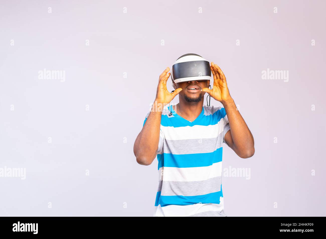 Young man using vr headset, experiencing virtual reality Stock Photo ...