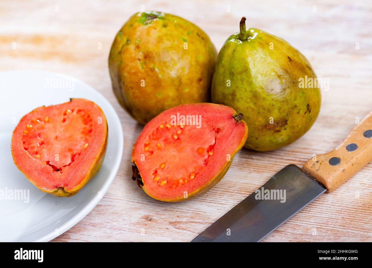 Fresh organic red guavas fruit cut in half on a wooden board. Exotic ...
