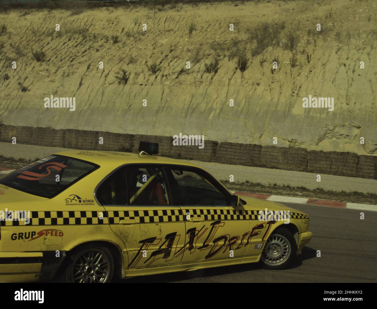 Modified yellow BMW E34 530i racing on the road during a competition in ...