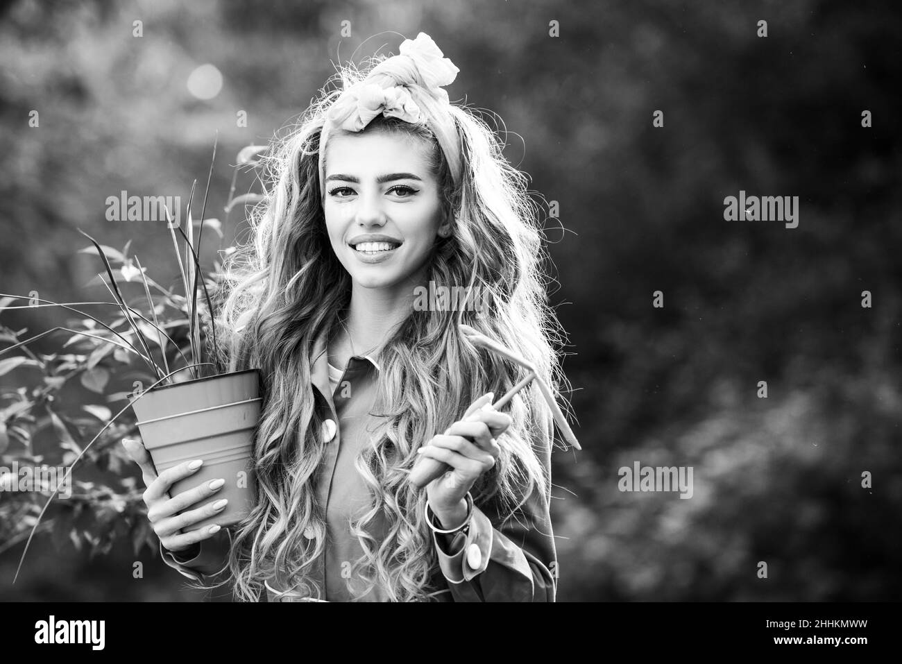 Beauty woman enjoying in the garden with flowers. Woman gardener grows ...