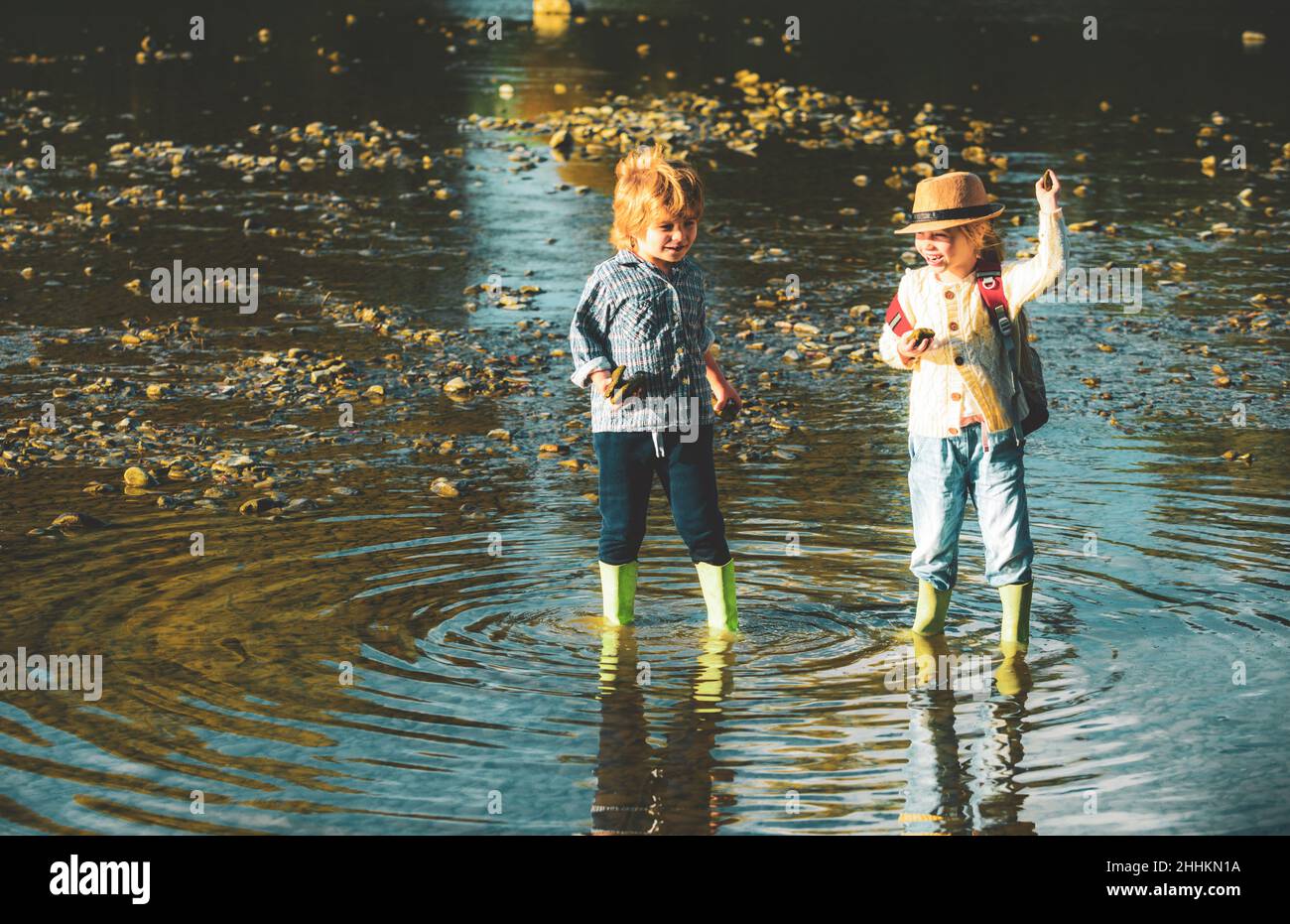 Children throw stones at the Stony river. Beautiful children throws a ...