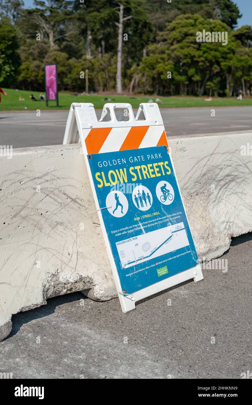 Sign reading Slow Streets on concrete barricade, park of the Slow ...