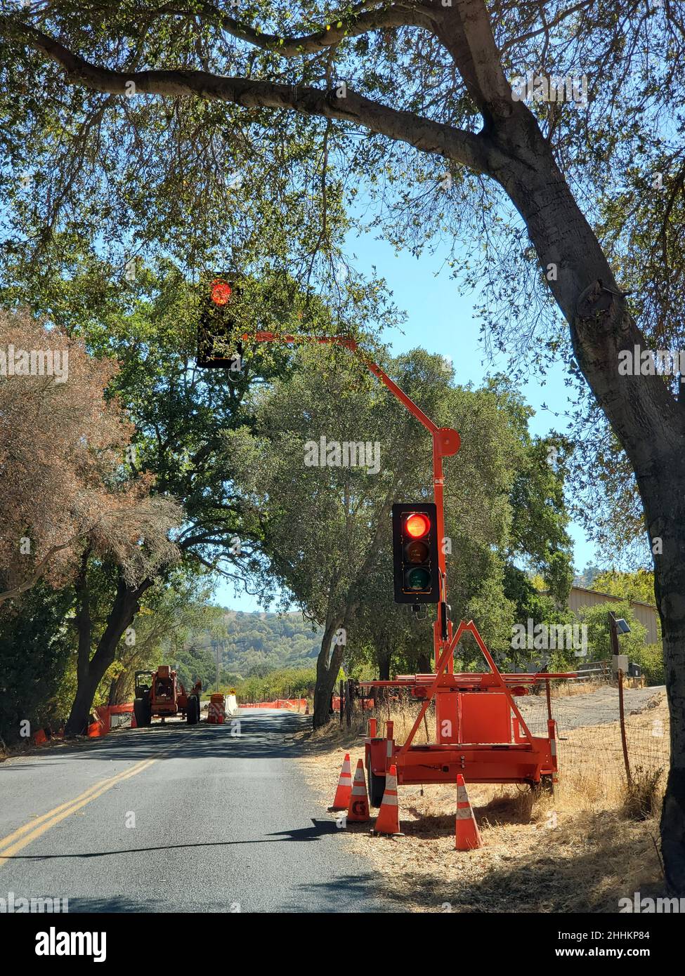 A temporary traffic light is visible beside a rural road during a ...