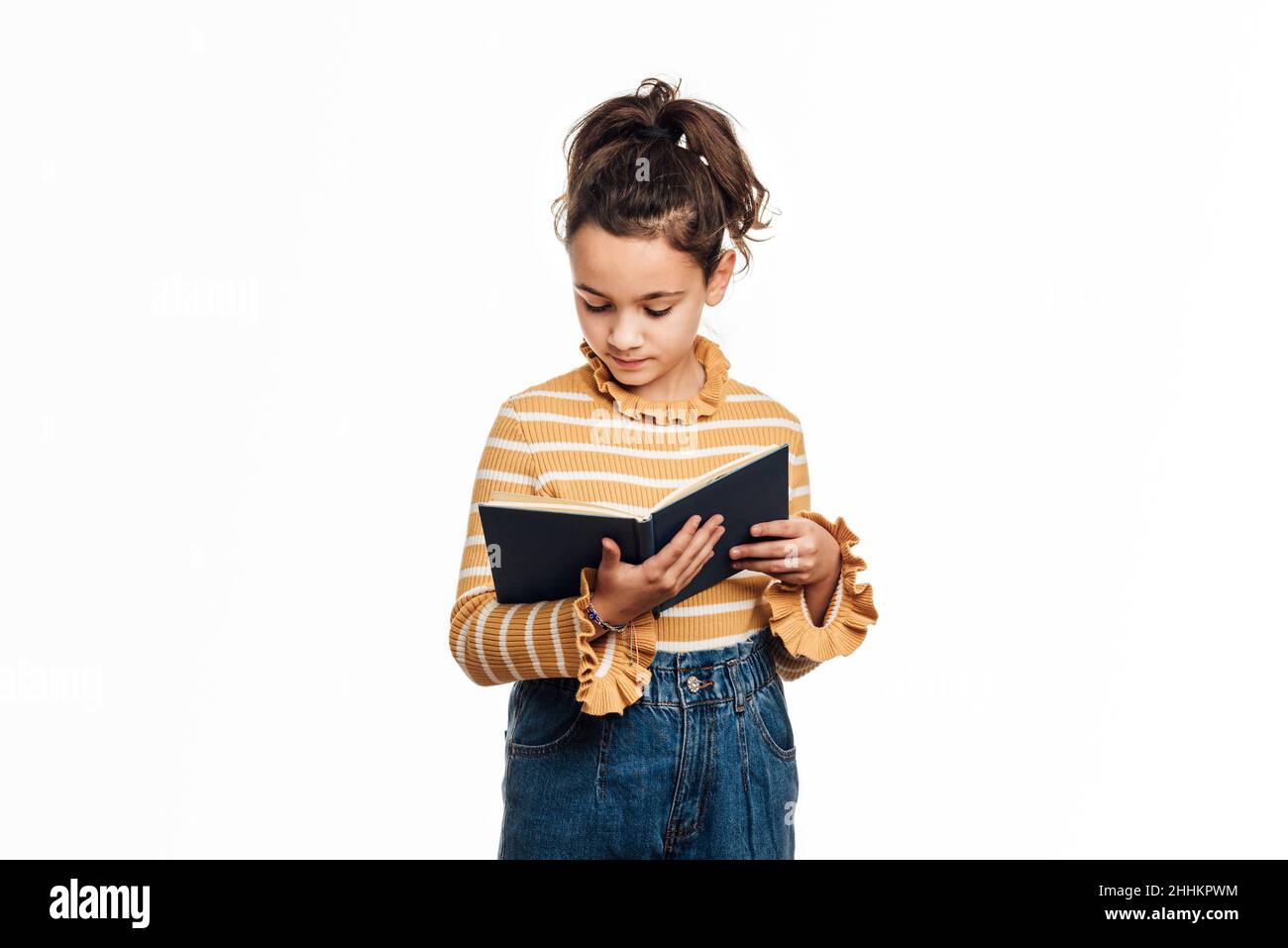 Concentrated girl reading a book while standing on an isolated ...