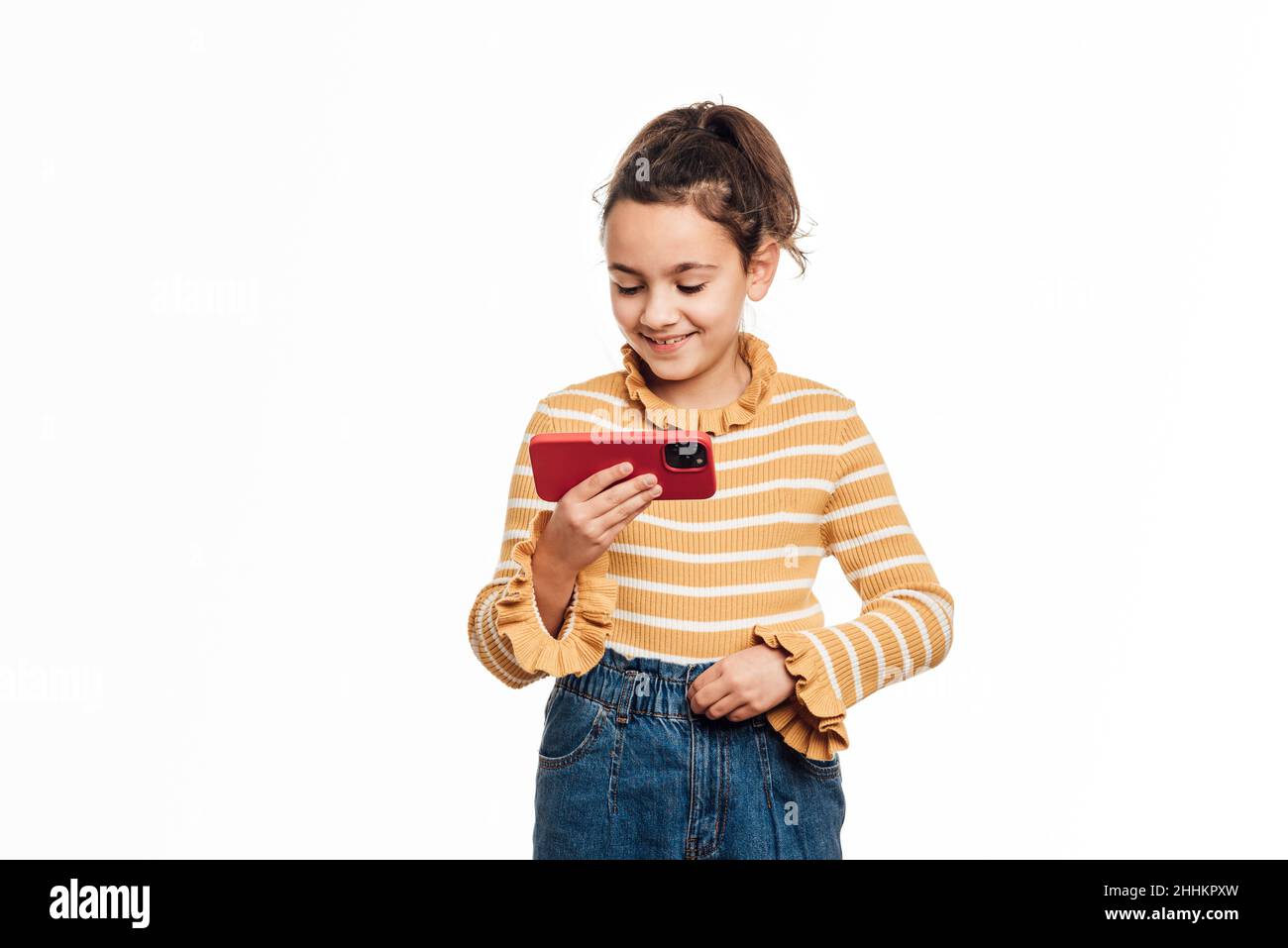 Girl using a mobile phone while standing on an isolated white ...