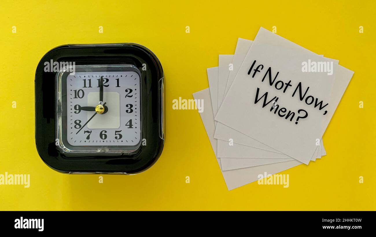 If not now, when - message on white notepad. With alarm clock and ...