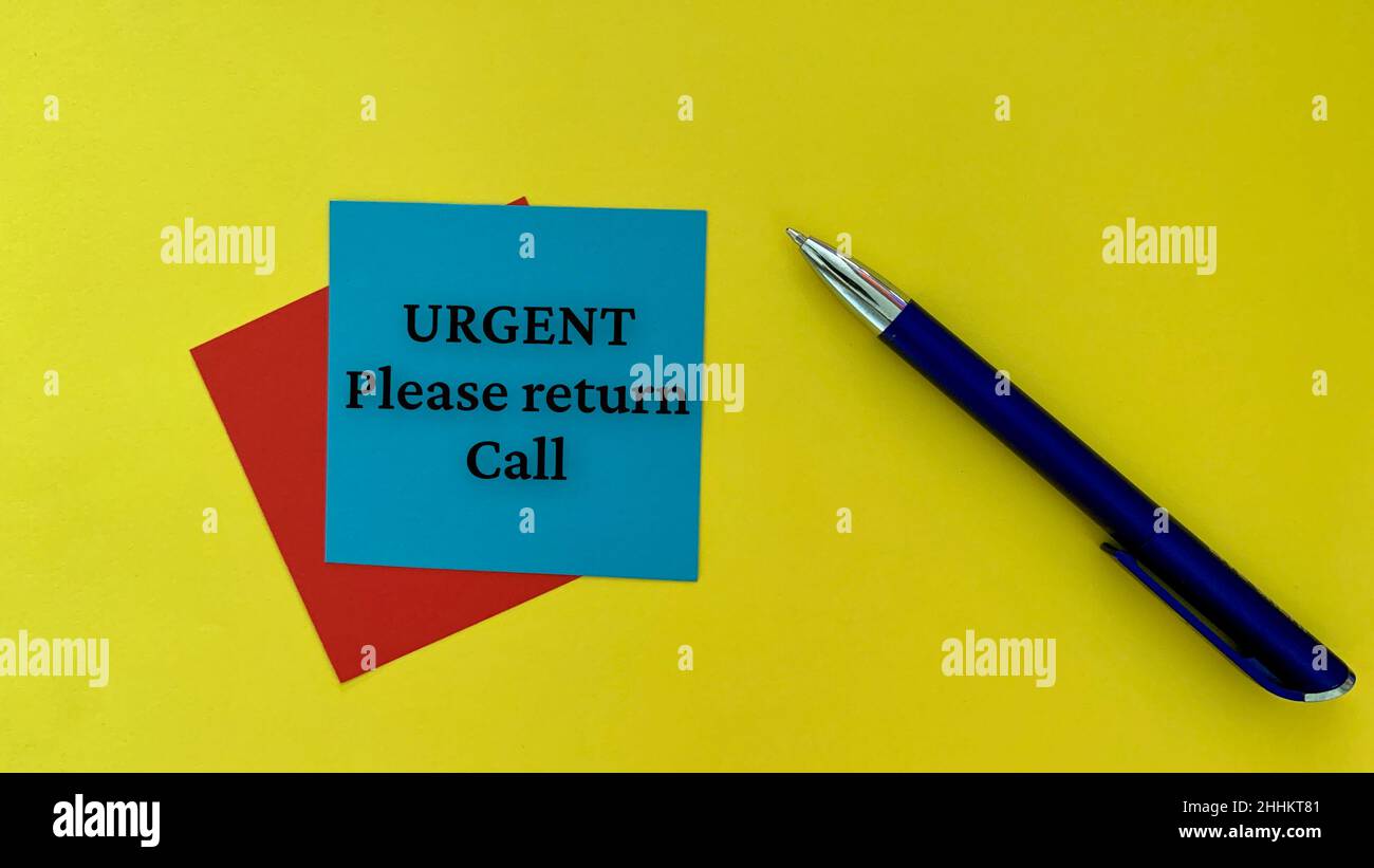 Urgent, please return call - message on blue notepad. With pen and ...