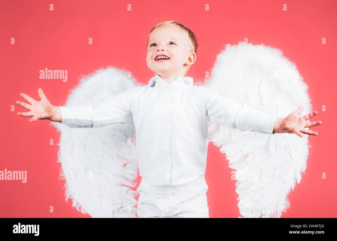 Child with angel wings isolated on red Stock Photo - Alamy