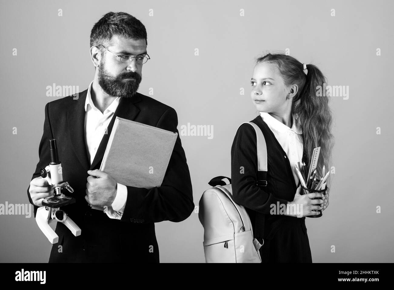 Cute schoolgirl with teacher in school. Studio portrait of tutor and ...