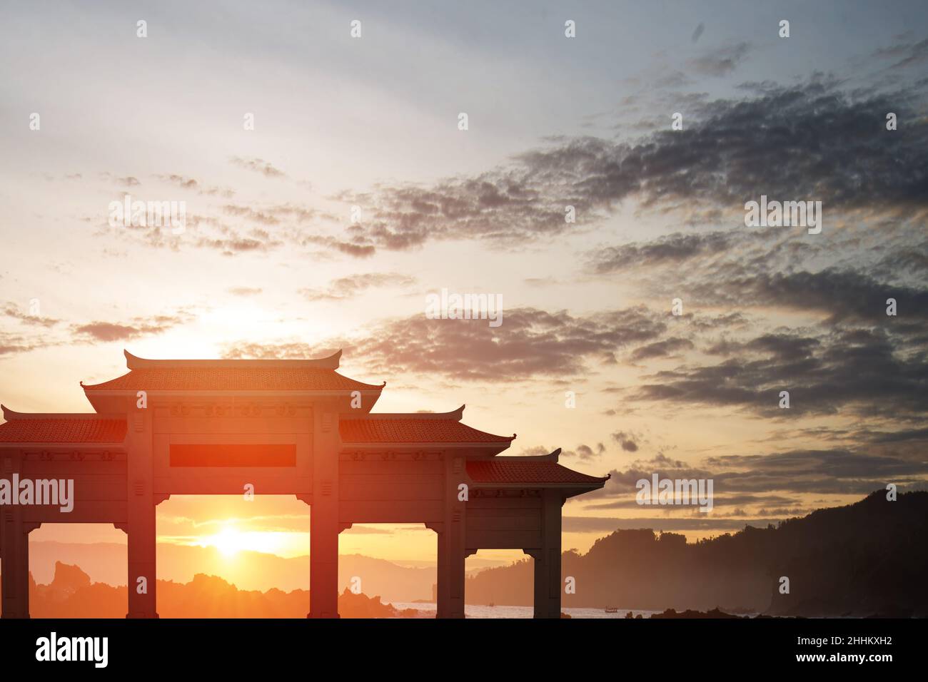 Chinese pavilion gate with red roof on the hill with dramatic sky ...
