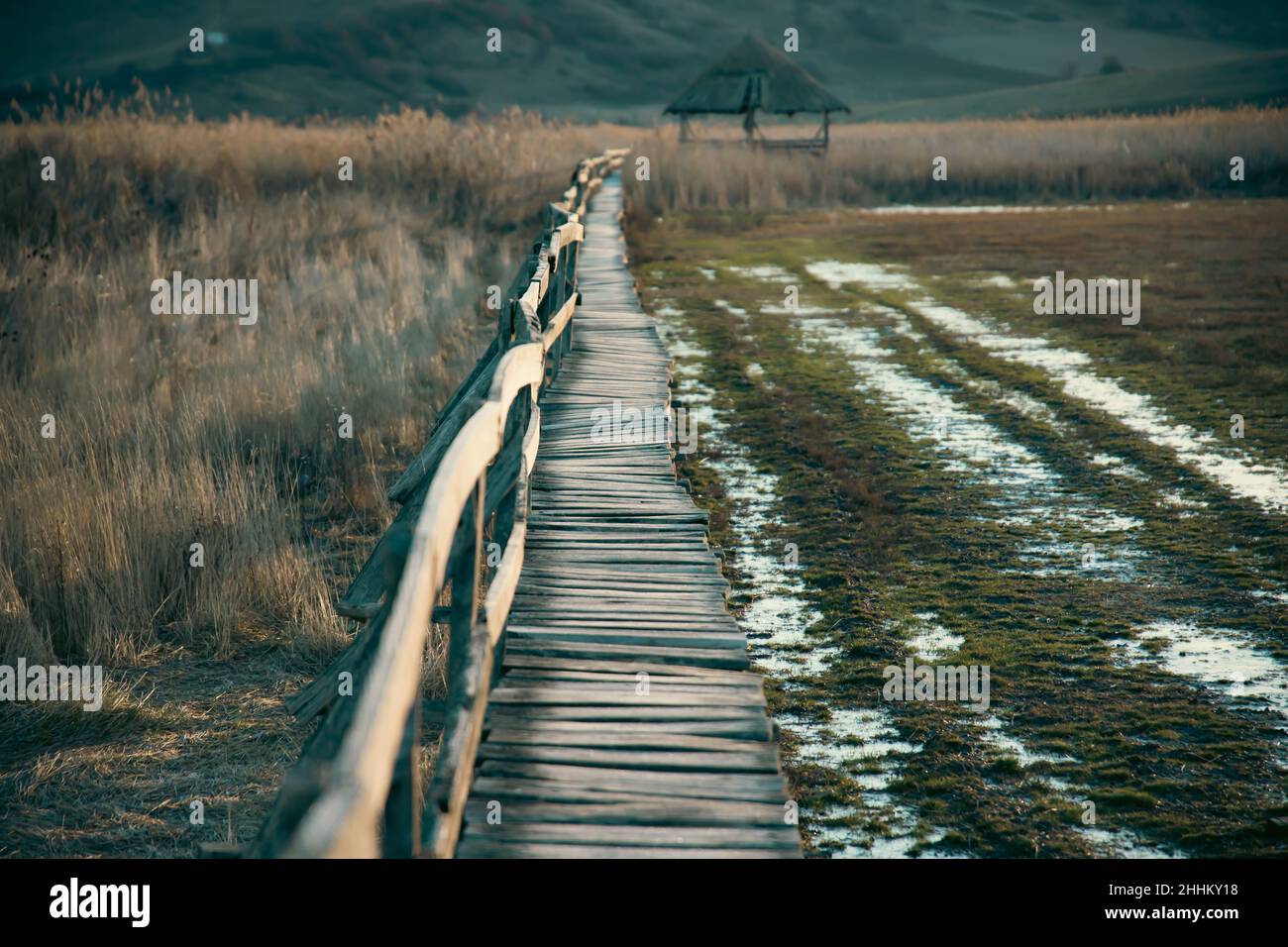 Old wooden boardwalk with a railing on the side and watchtower in the ...