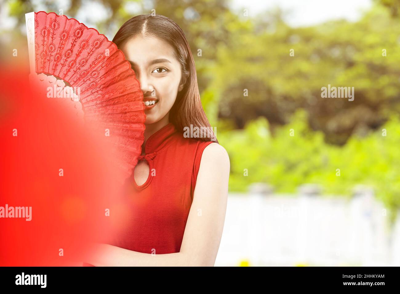 Asian Chinese woman in a cheongsam dress holding fan celebrates Chinese ...
