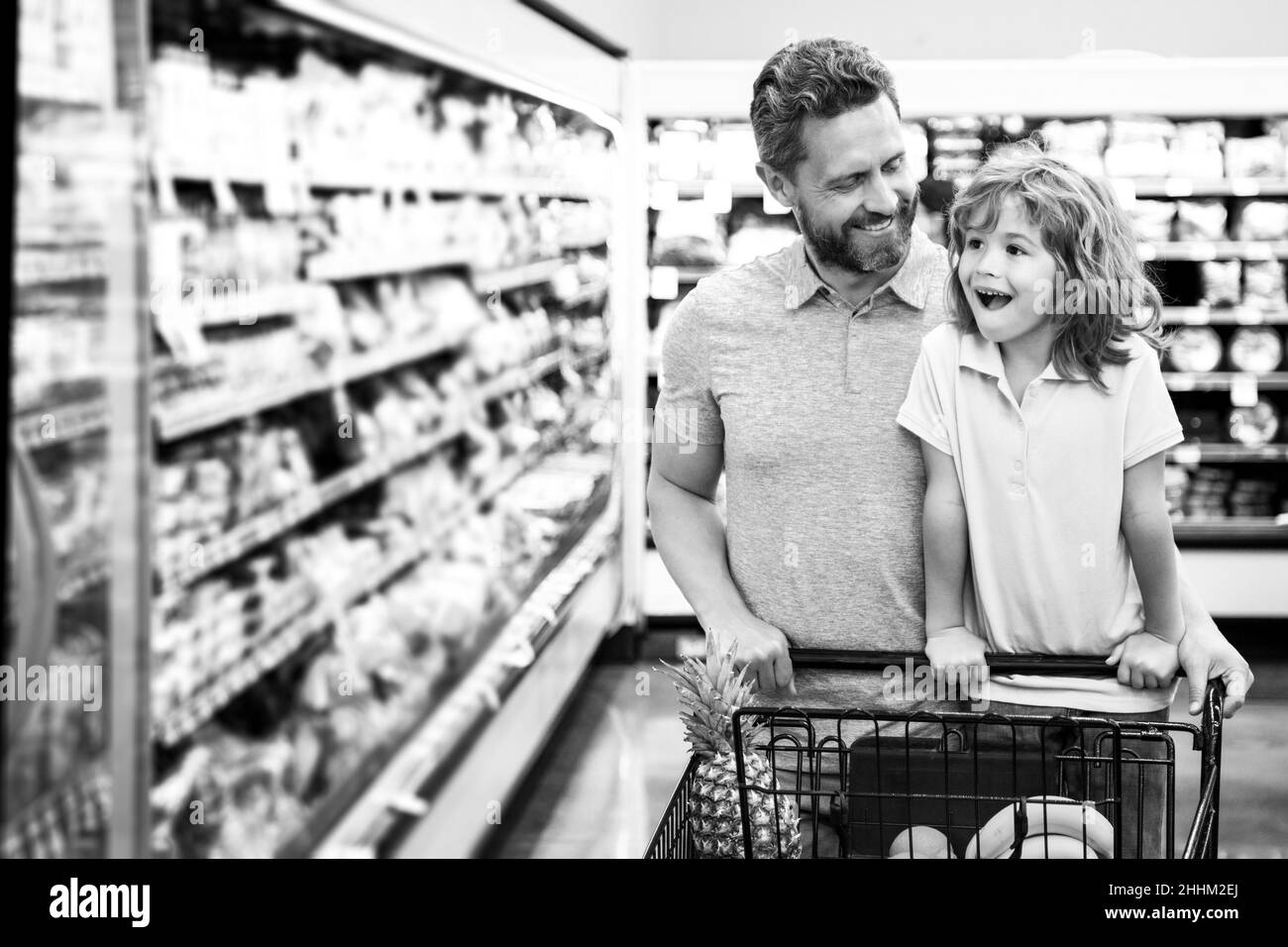 Father and son looking at product at grocery store. Dad with child in ...