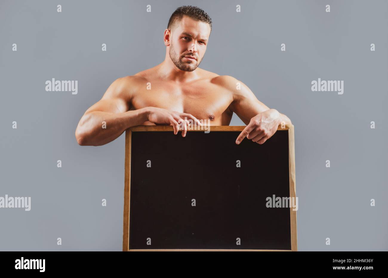 Bodybuilder man with sign advertising board. Strong athlete holding ...
