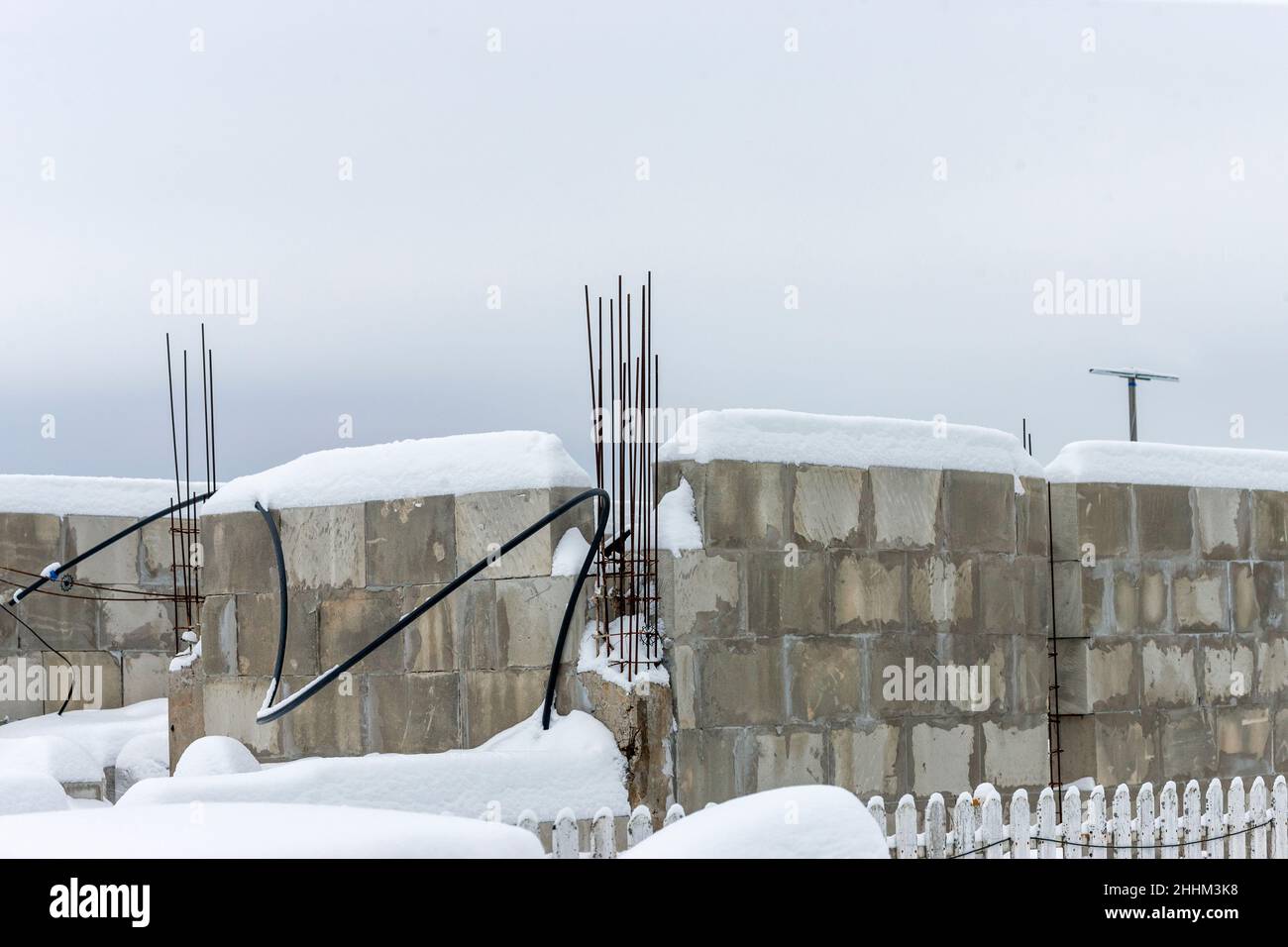 unfinished building made of concrete blocks and sticking out rusty ...