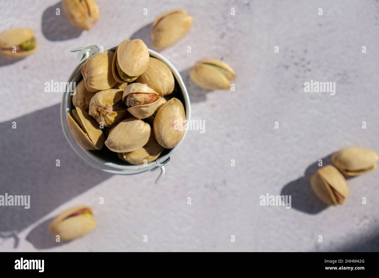 Pistachios in white bucket on concrete background. Healthy and dietary ...