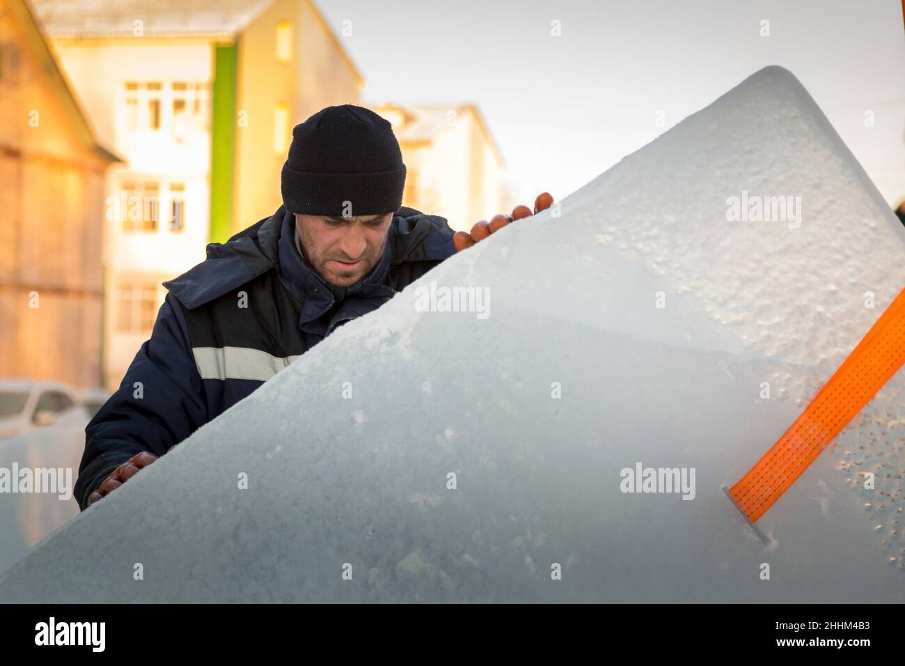 Fitter in a blue hooded jacket at an ice slab installation Stock Photo ...