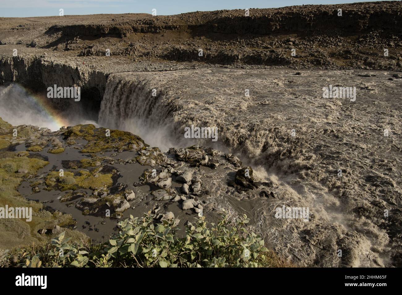 Rainbow and dark gray water of brutal waterfall in Iceland Stock Photo ...