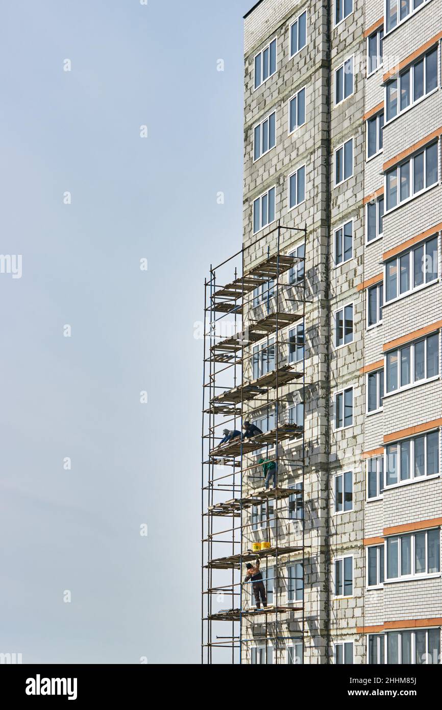 Installation of scaffolding. Builders work without means of protection ...