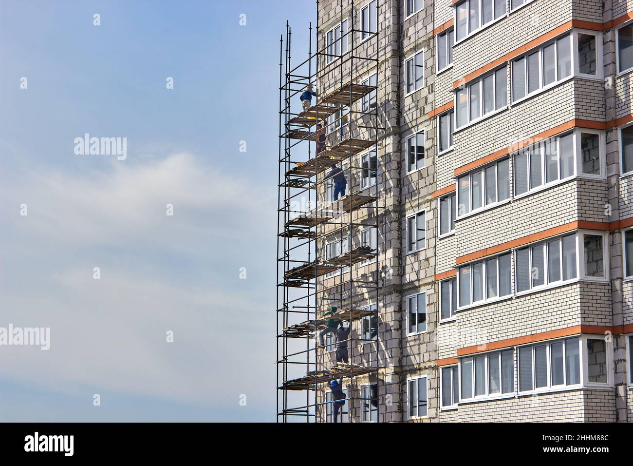 Installation of scaffolding. Builders work without means of protection ...