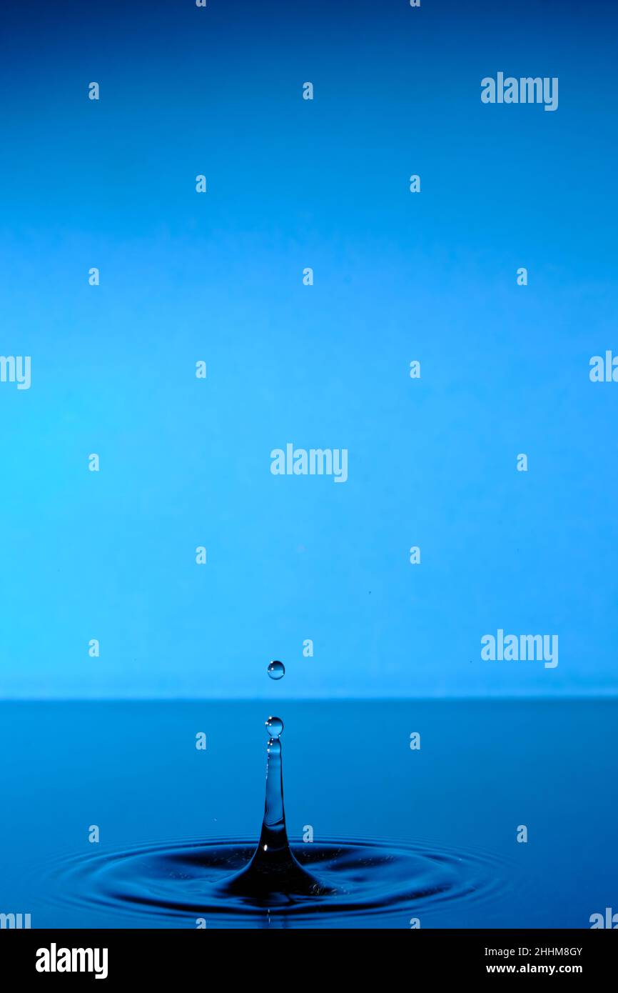 Water splashes after raindrop falls.Blue abstract background with ...