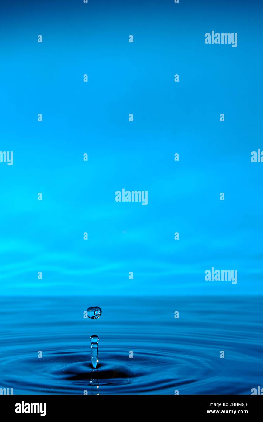 Water splashes after raindrop falls.Blue abstract background with ...