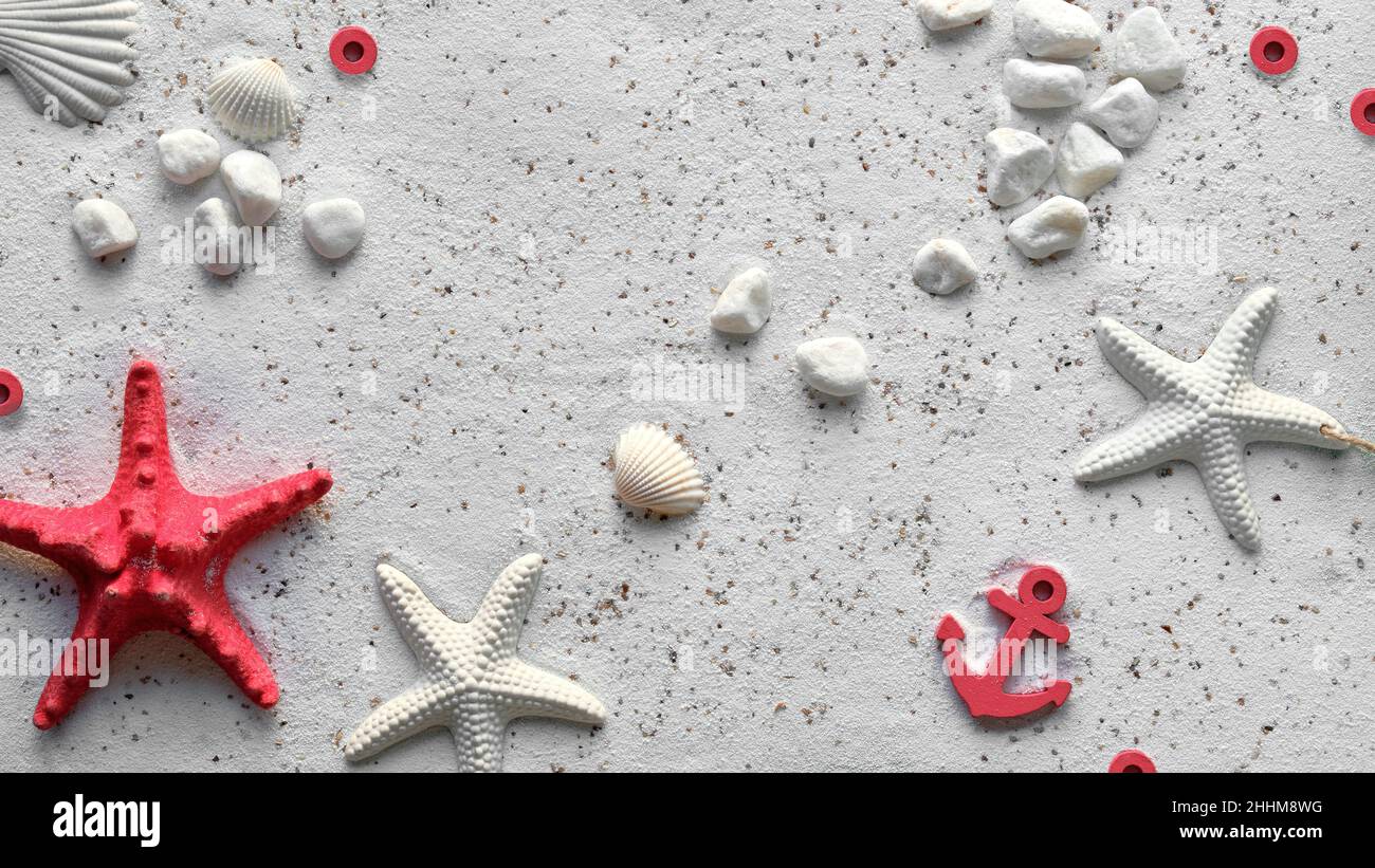 White sand background, beige seashells, red starfish and pebbles. Off ...
