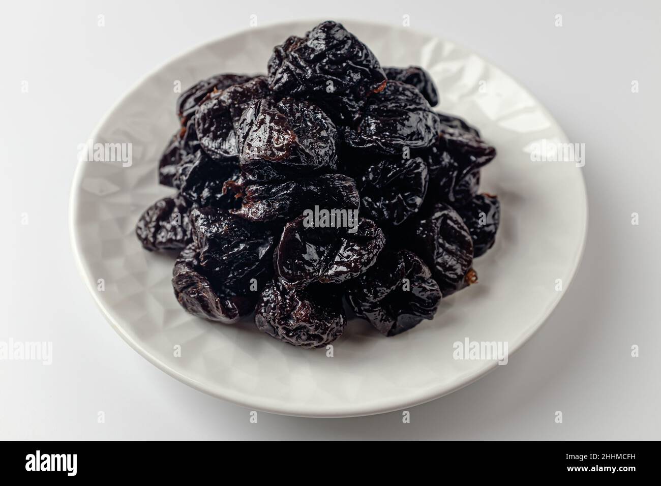dried plums on a white background Stock Photo - Alamy