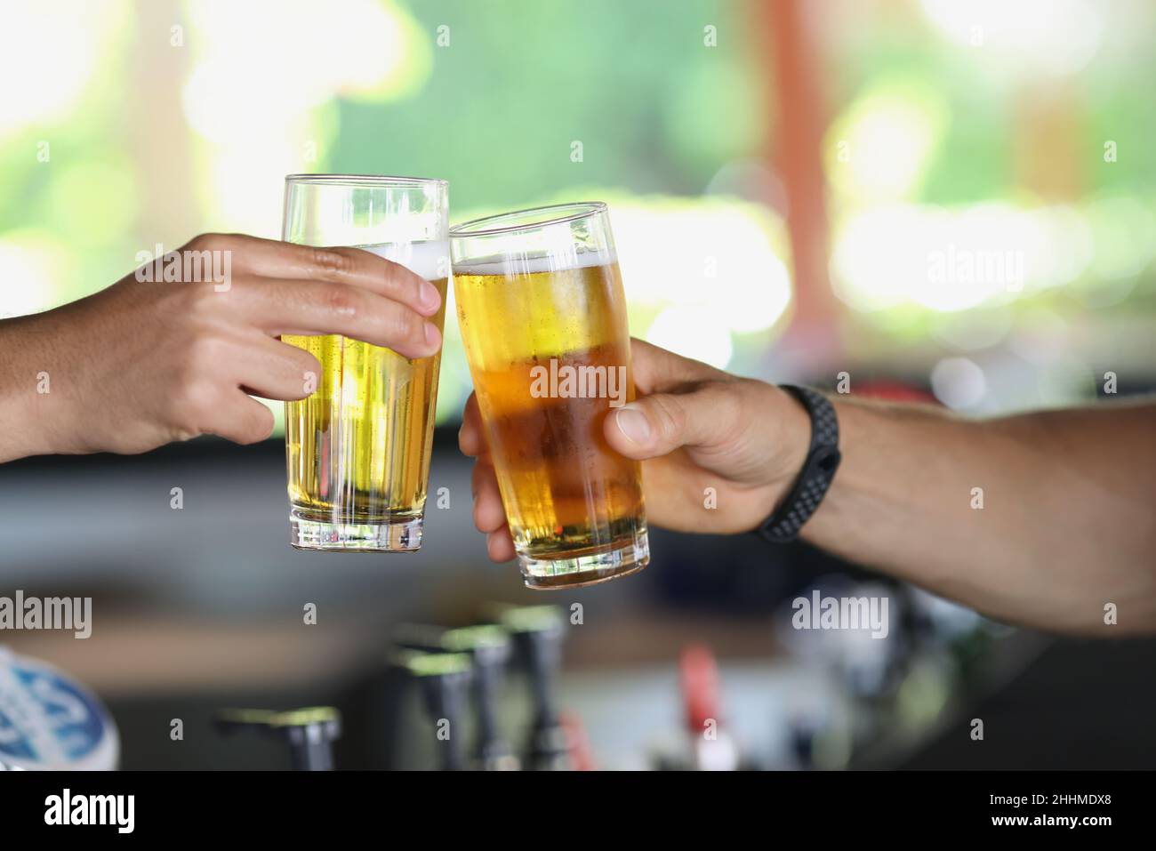 Male hands with glasses of beer clink glasses Stock Photo - Alamy