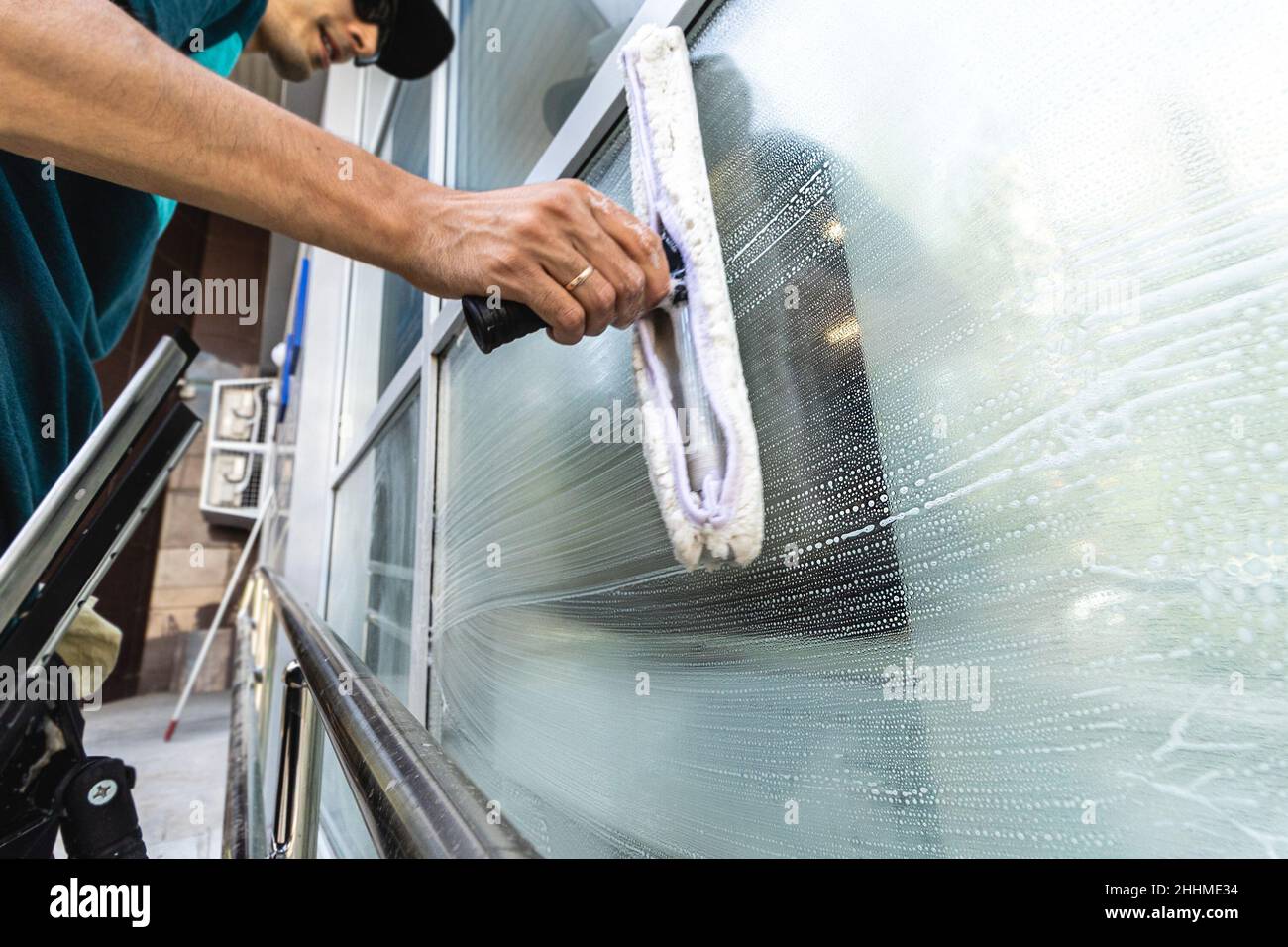 An employee of a professional cleaning service in overalls washes the ...