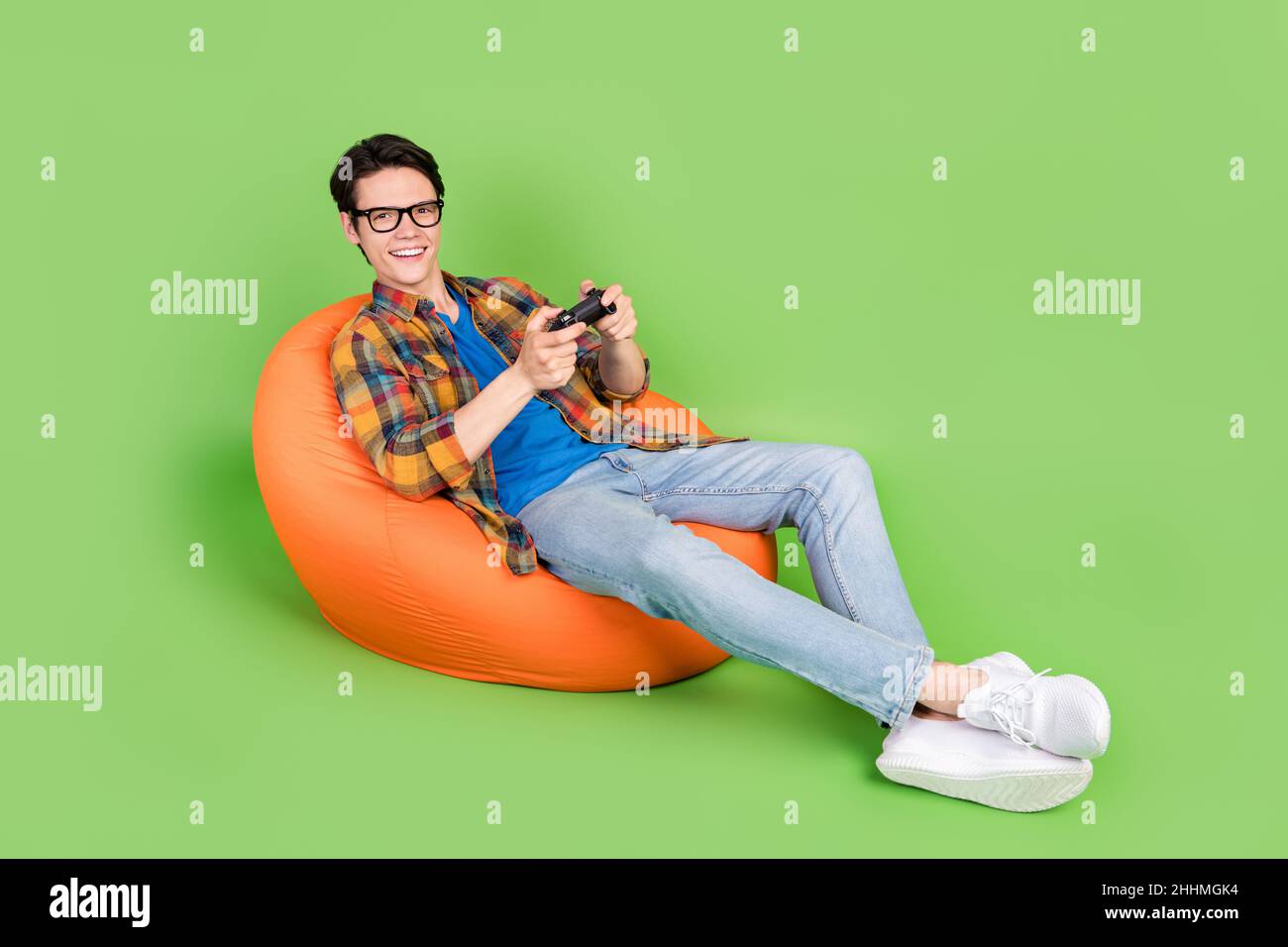 Photo of gamer guy hold joystick play video game wear specs checkered ...