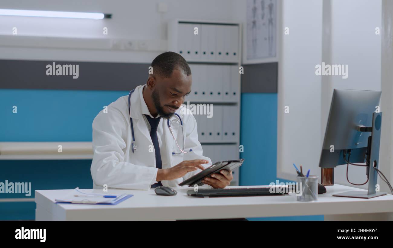 African american therapist doctor sitting at desk in hospital office ...