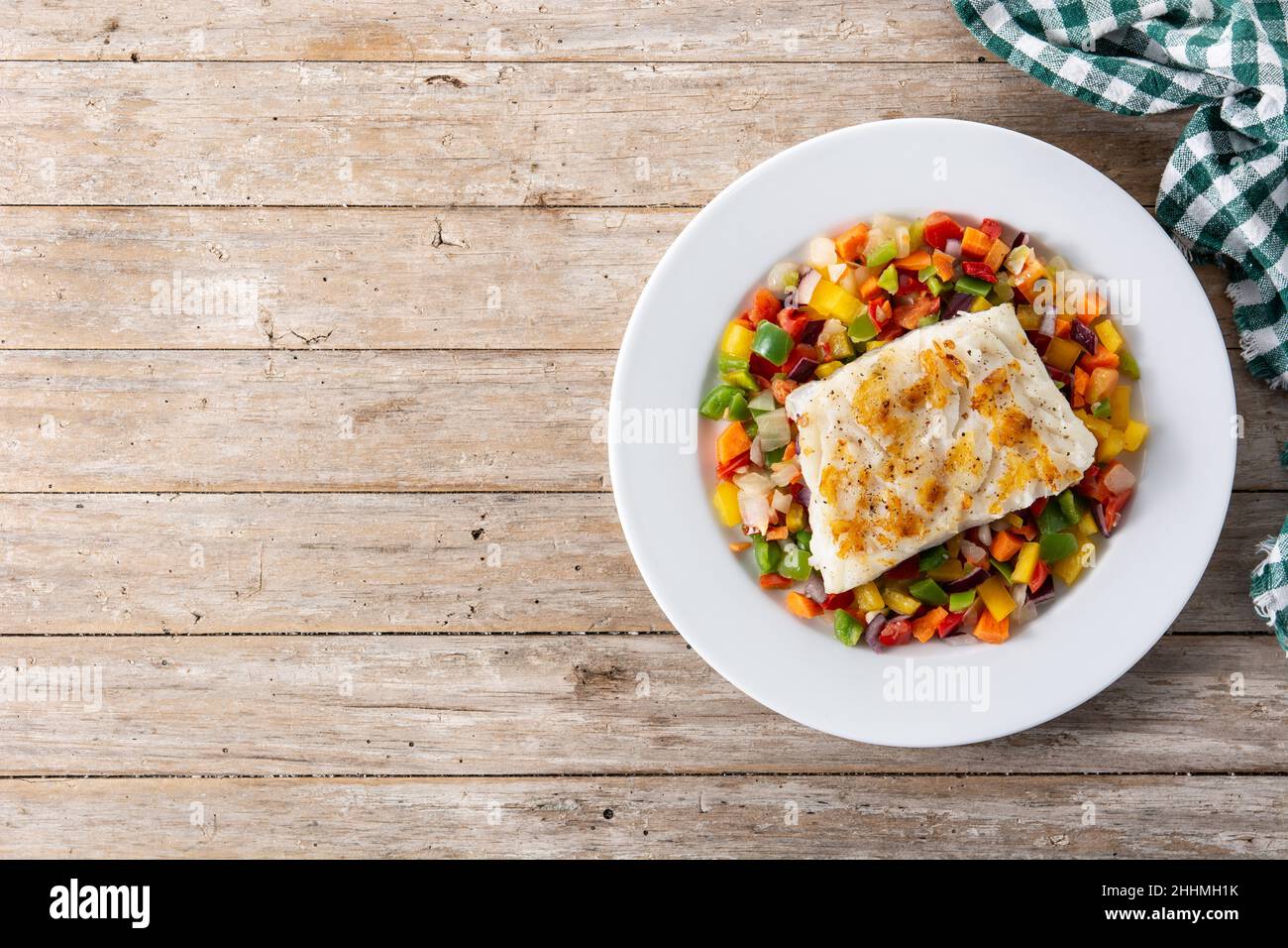 Grilled cod with vegetables in plate on wooden table Stock Photo - Alamy
