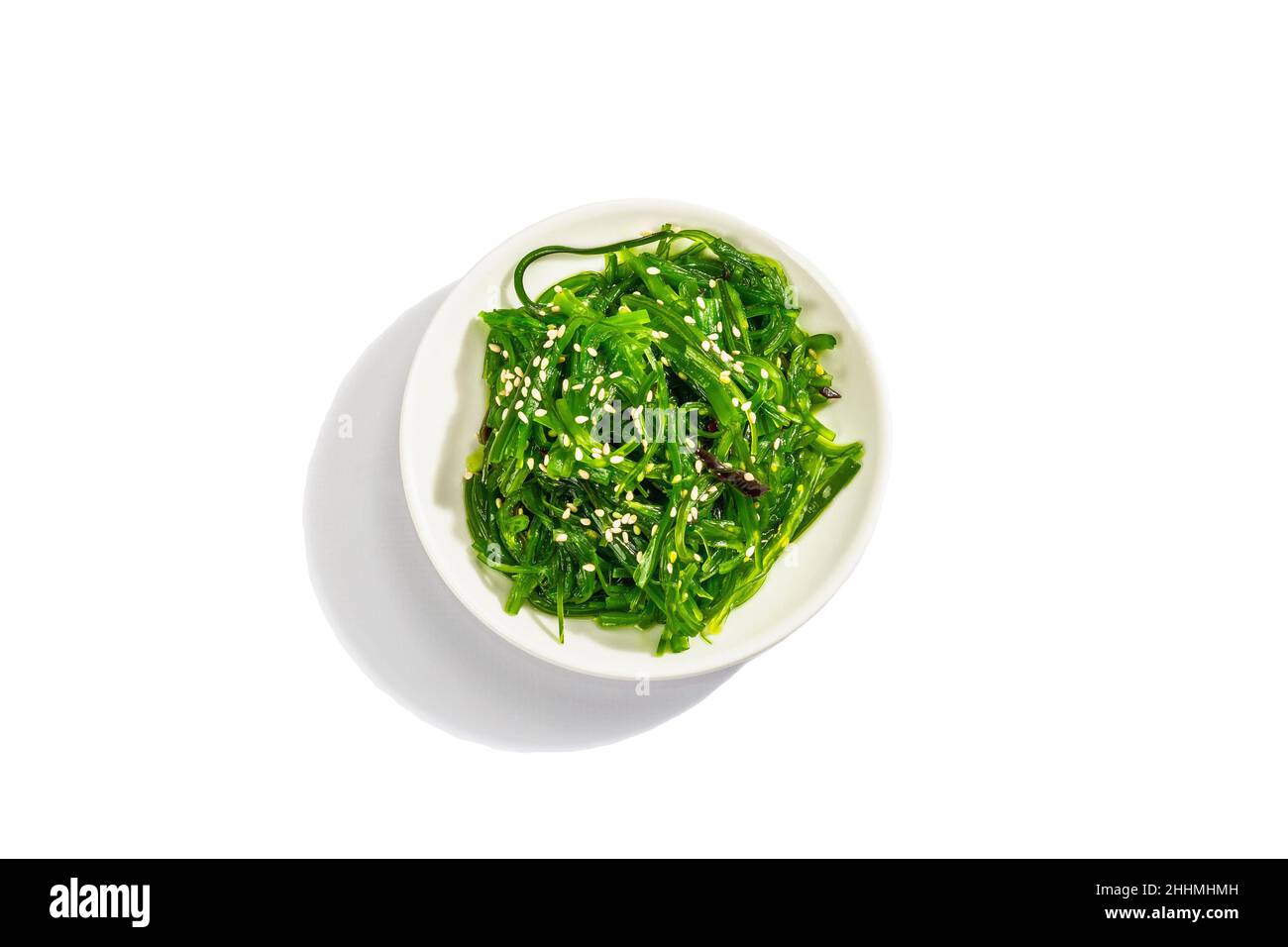 Chuka Seaweed Salad with sesame seeds isolated on white background. Trendy hard light, dark ...