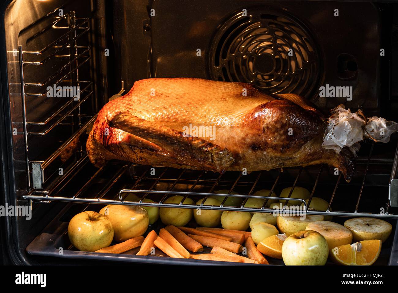 Festive Christmas goose with fried vegetables and fruit in the oven ...