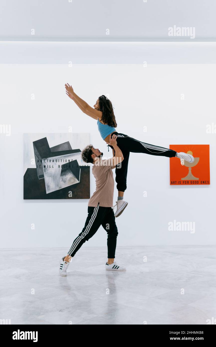 Lovely young Spanish couple dancing in the studio covered in ...