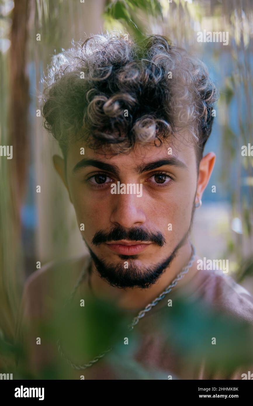 Portrait of an attractive young Spanish man with hair highlights and ...