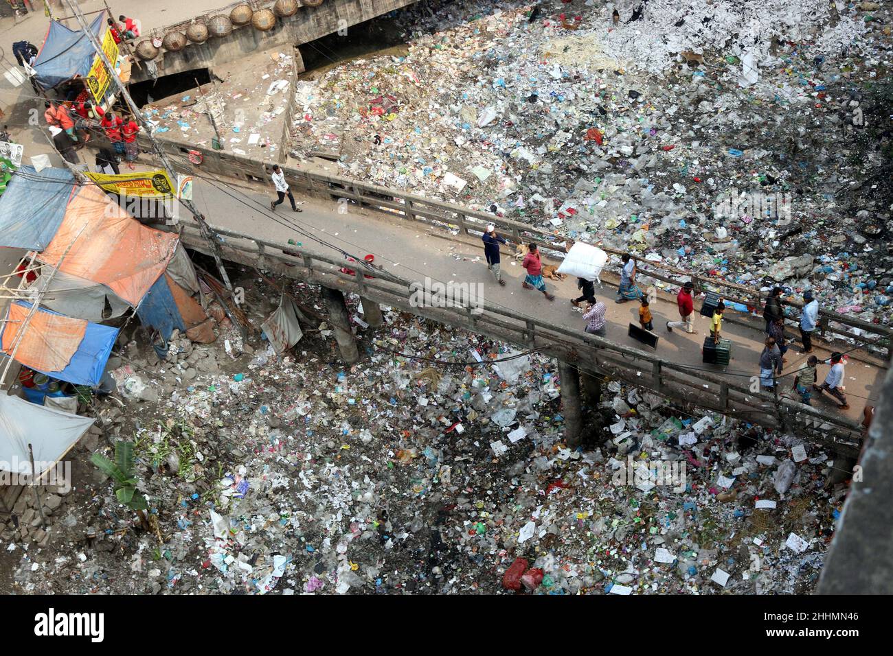 JANUARY 25,2022,DHAKA,BANGLADESH- People walk along a bridge over a ...