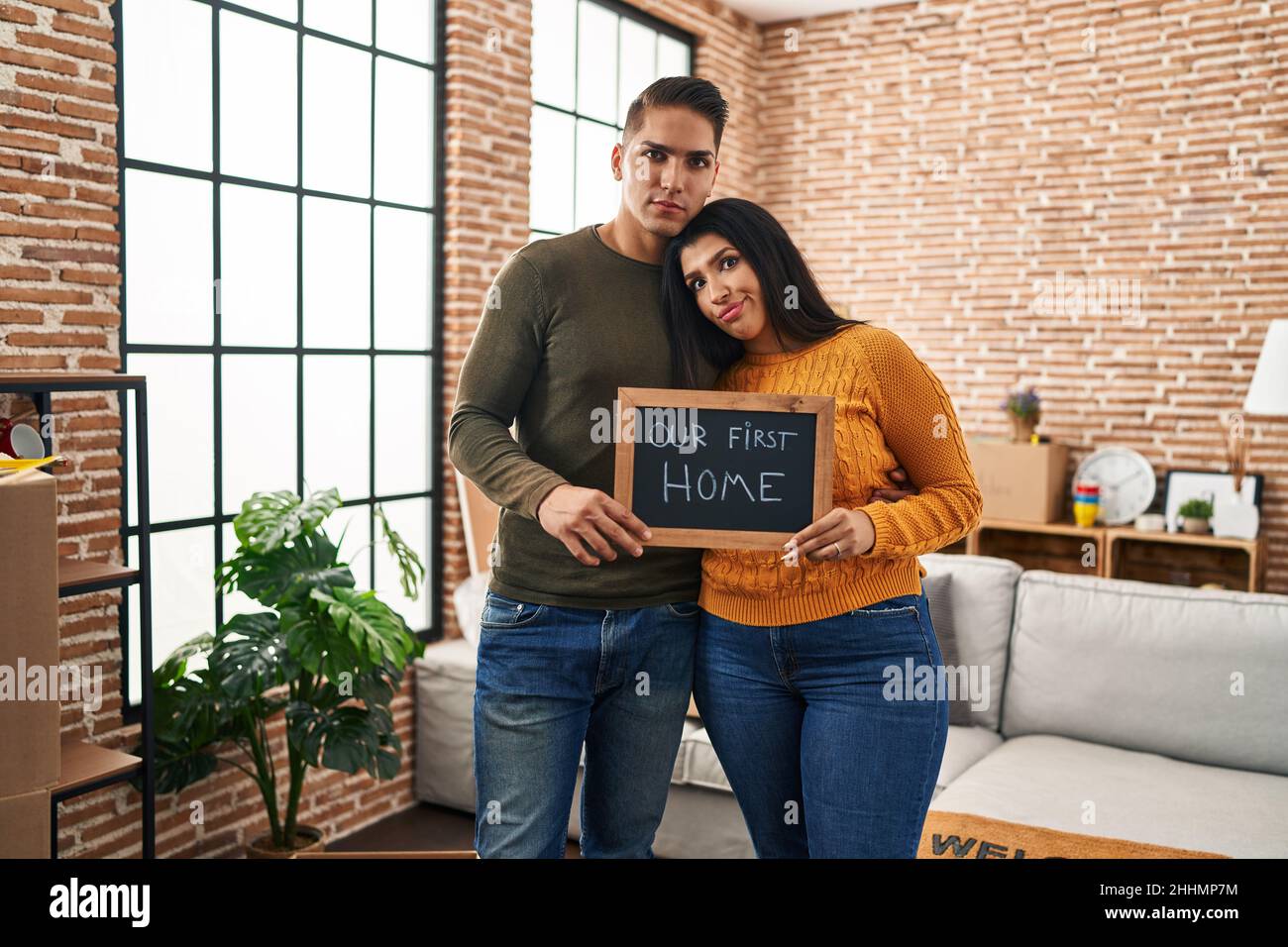 Young couple moving to a new home skeptic and nervous, frowning upset because of problem ...