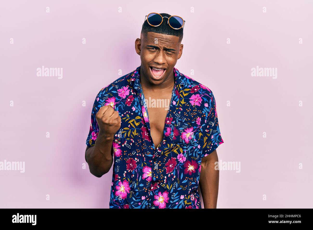 Young black man wearing hawaiian shirt and sunglasses angry and mad ...