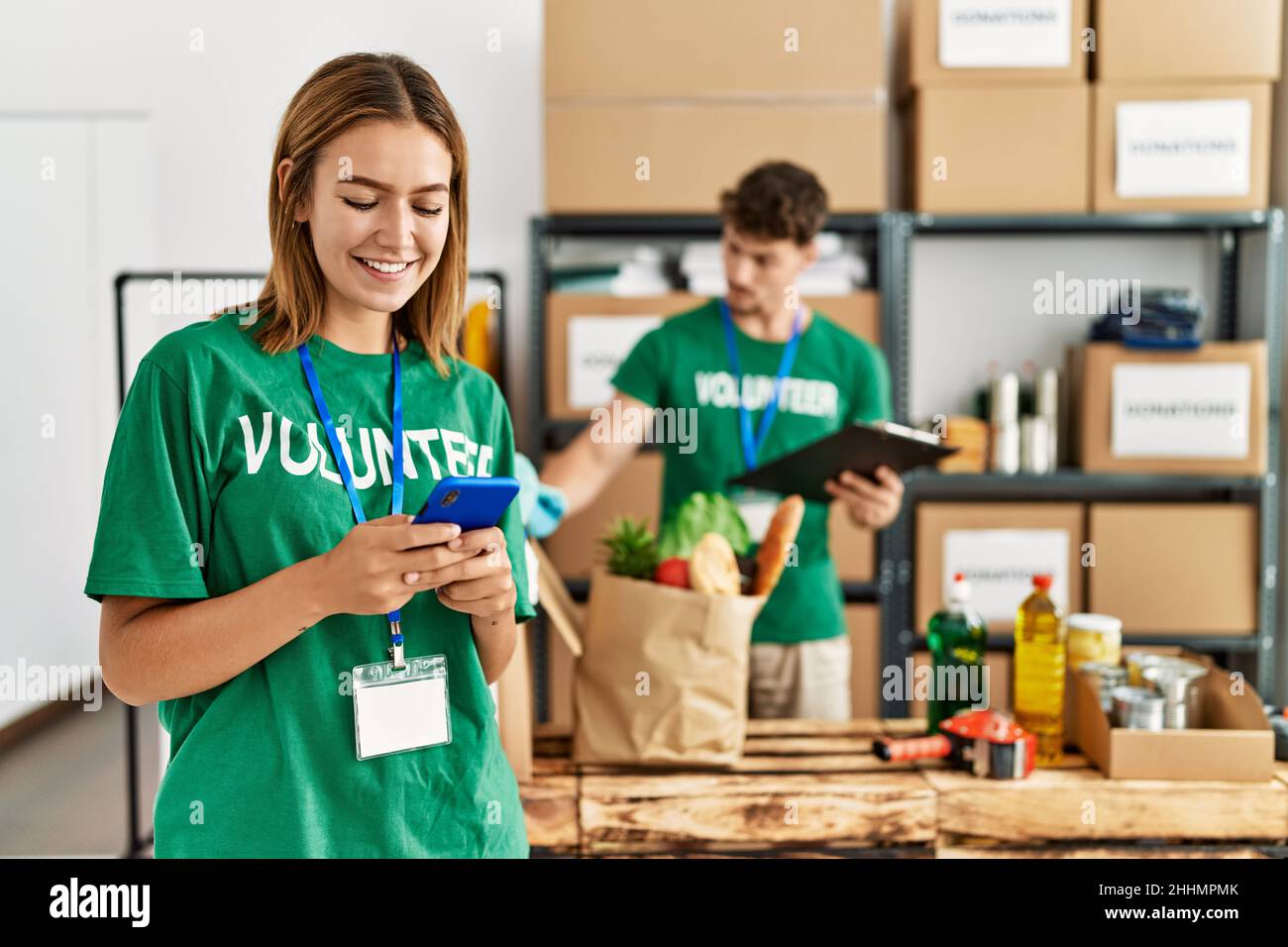 Young hispanic volunteer couple working at charity center. Woman ...