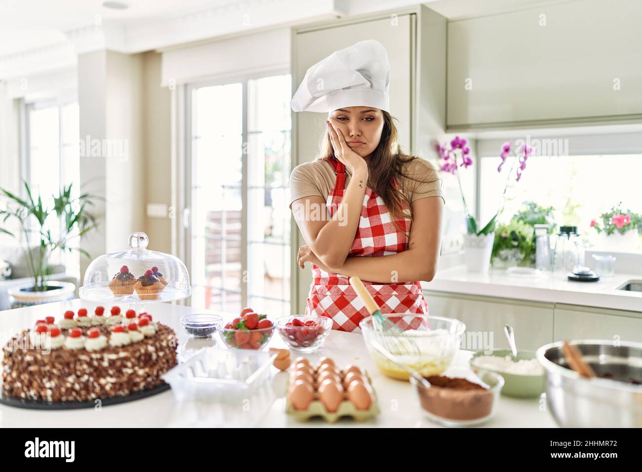 Beautiful young brunette pastry chef woman cooking pastries at the ...
