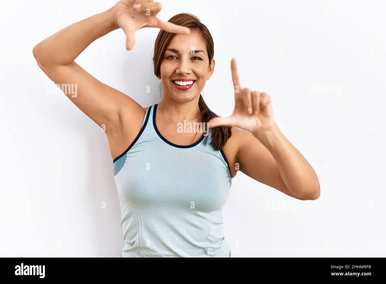 Young latin woman wearing sporty clothes over isolated background ...