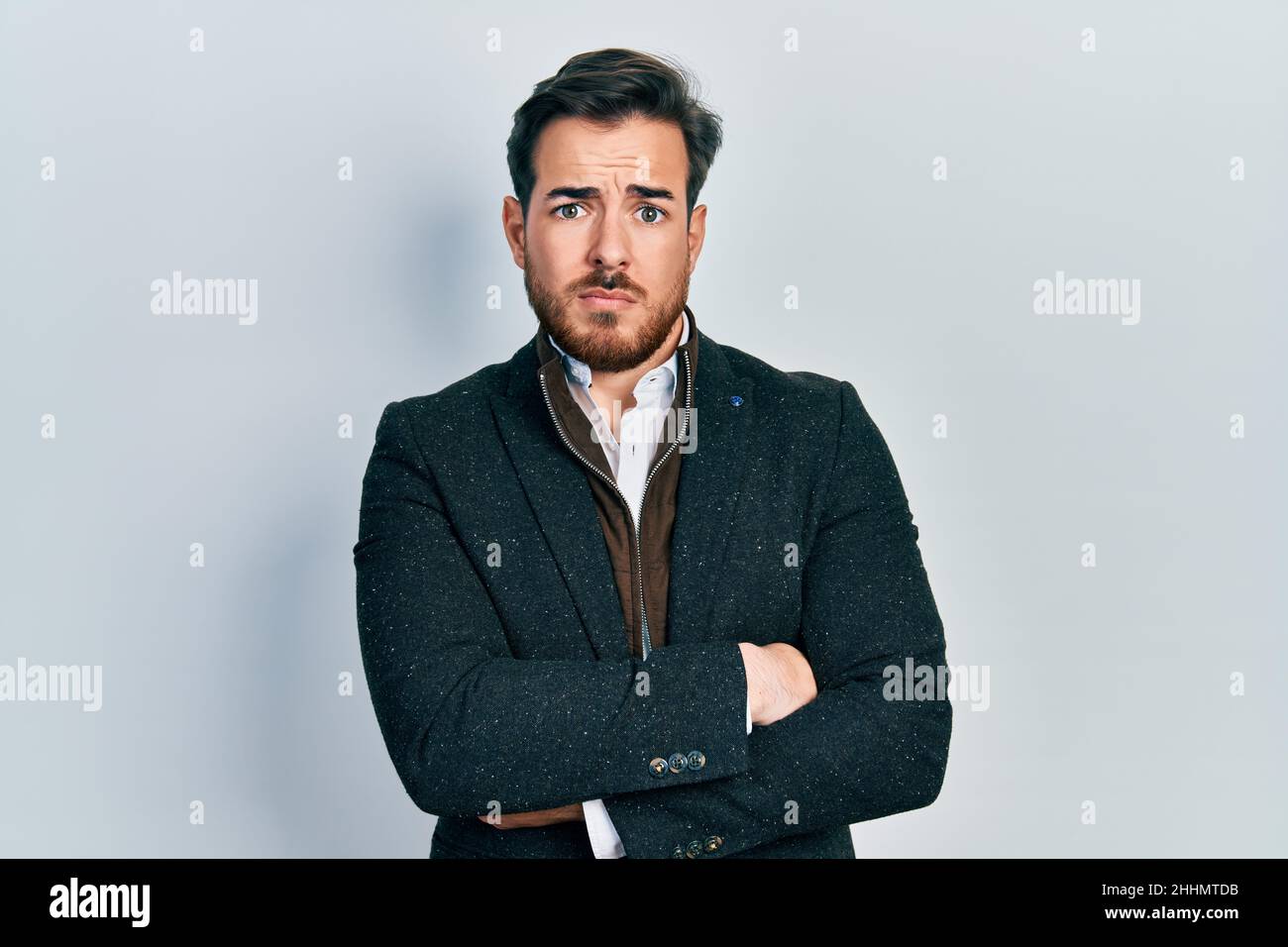 Handsome caucasian man with beard with arms crossed gesture skeptic and ...