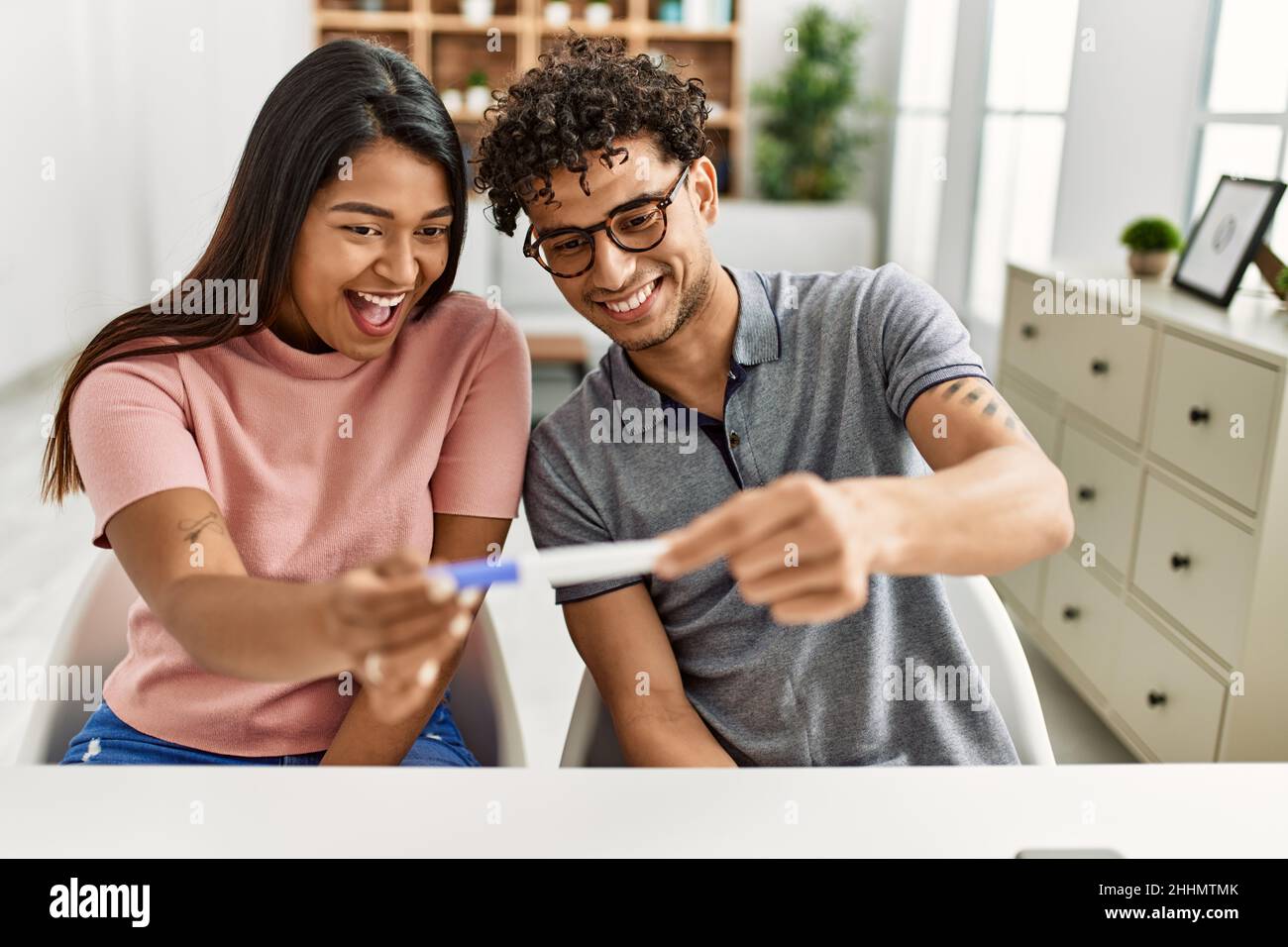 Young latin couple smiling happy holding pregnancy test sitting on the ...