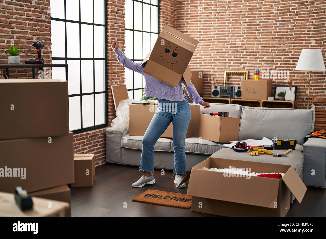 Young african american woman dancing with funny cardboard box on head ...