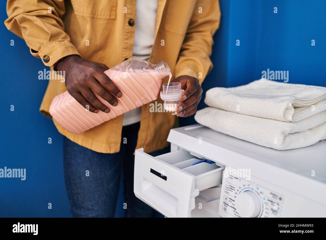Young african american man smiling confident pouring detergent on ...