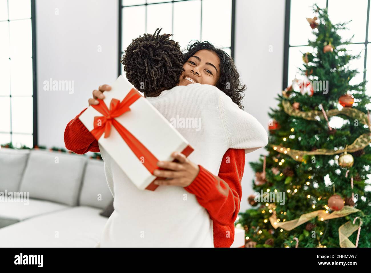 Young interracial couple smiling happy and hugging holding christmas ...