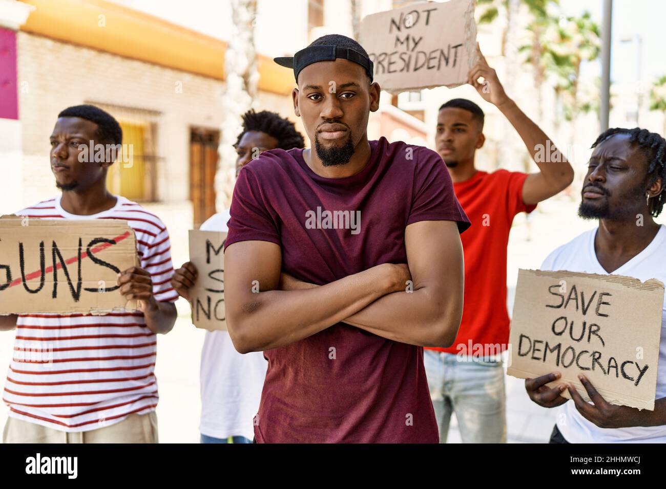 Young activist man with arms crossed gesture standing with a group of ...