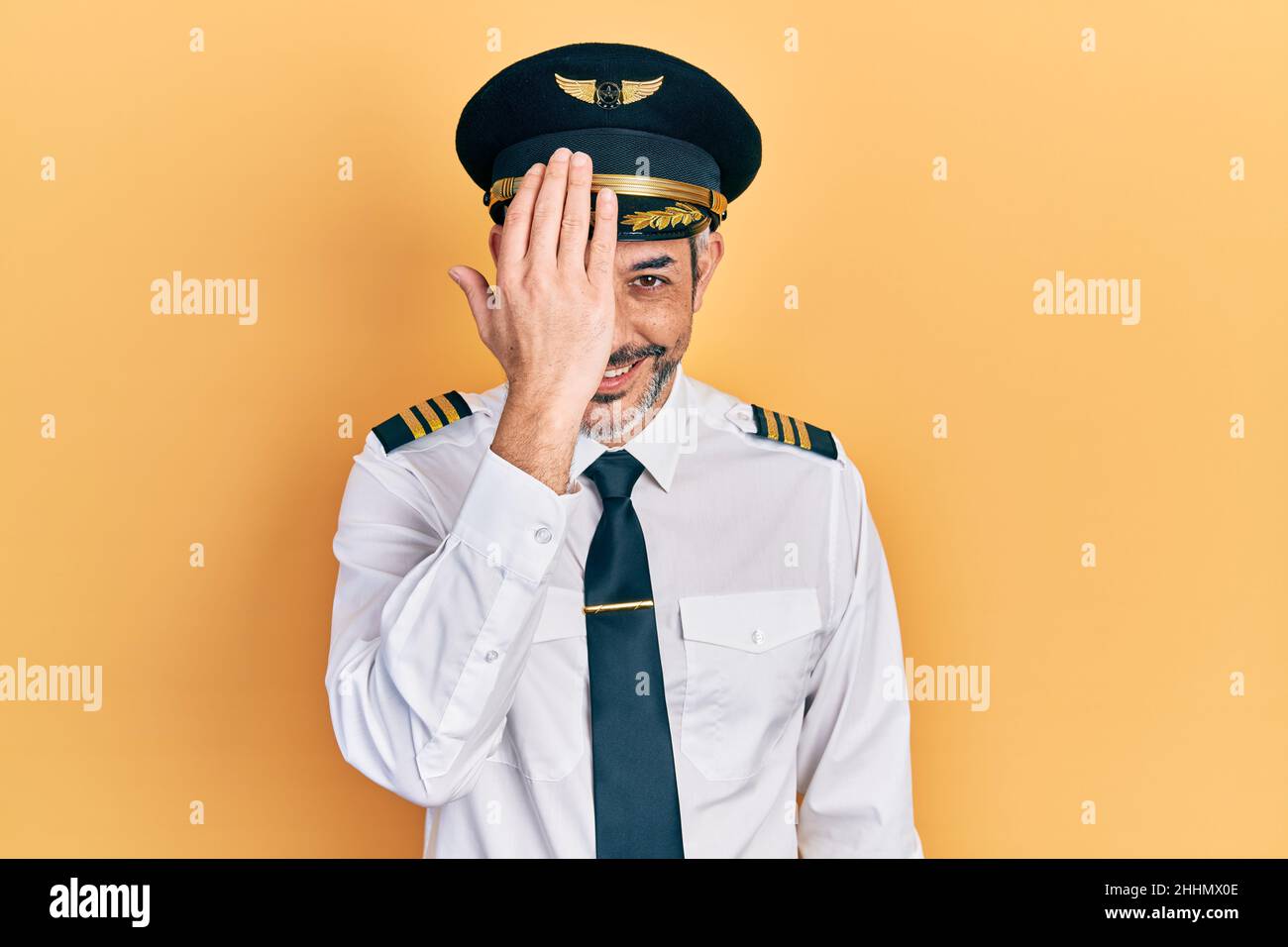 Handsome middle age man with grey hair wearing airplane pilot uniform ...